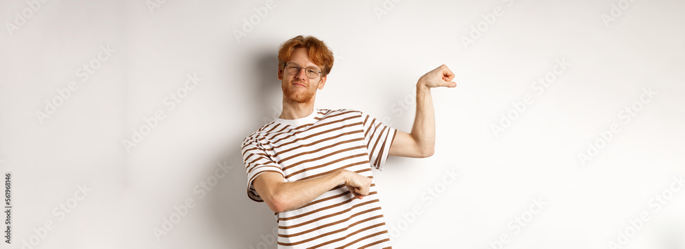 Image of confident and strong redhead man flexing biceps, showing ...