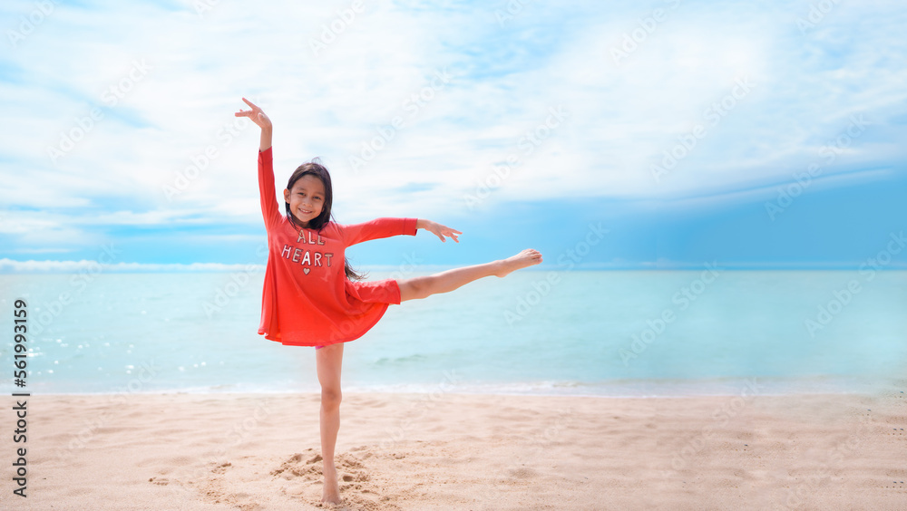 Asian little girl is dance ballet on the beach with happy moment ...