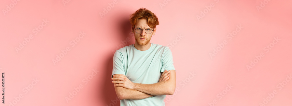 Angry man in glasses with red hair frowning, cross arms on chest in ...