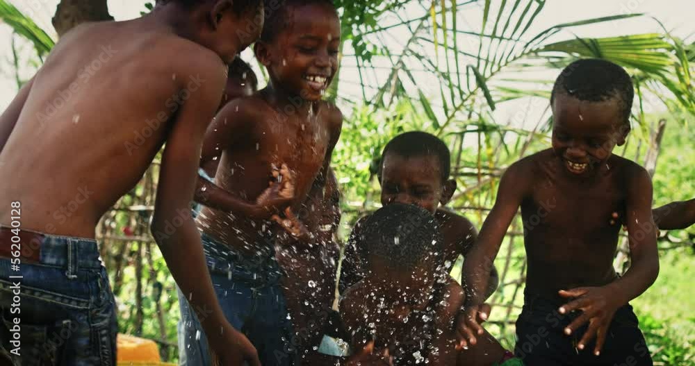 A Group Of African Children, Laughing and Playing with Water in Rural ...