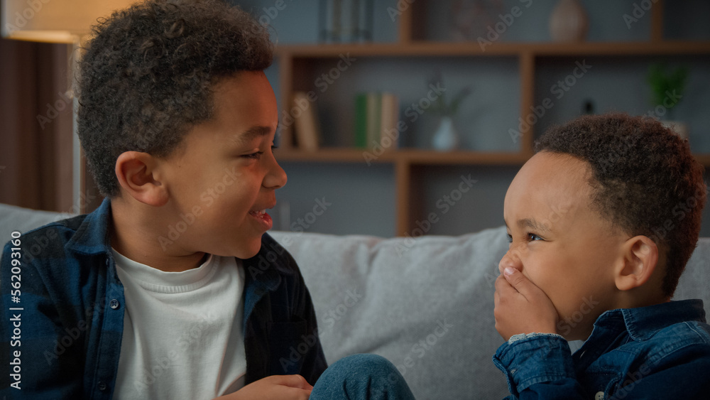 Two little boys friendly talking laughing at home. Ethnic African ...
