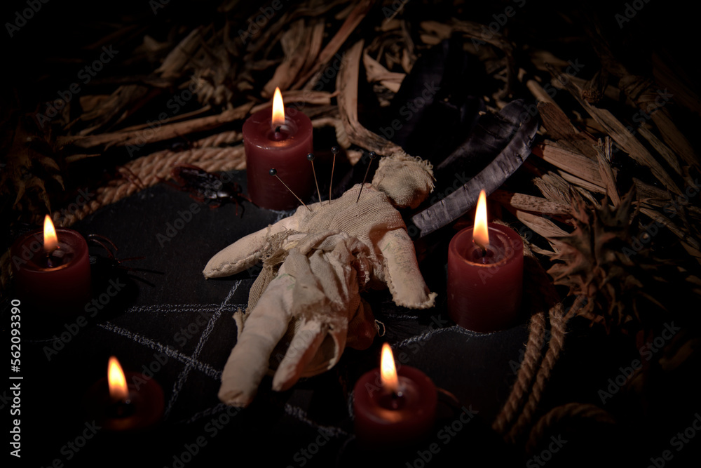 Voodoo doll, black candles, pentagram and old books on witch table ...
