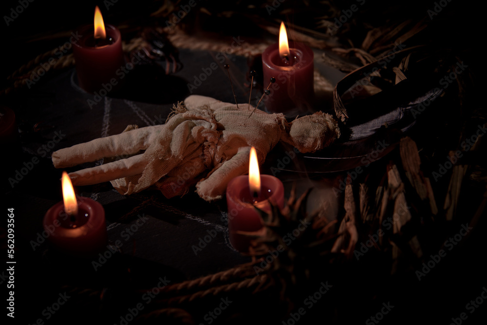 Voodoo doll, black candles, pentagram and old books on witch table ...
