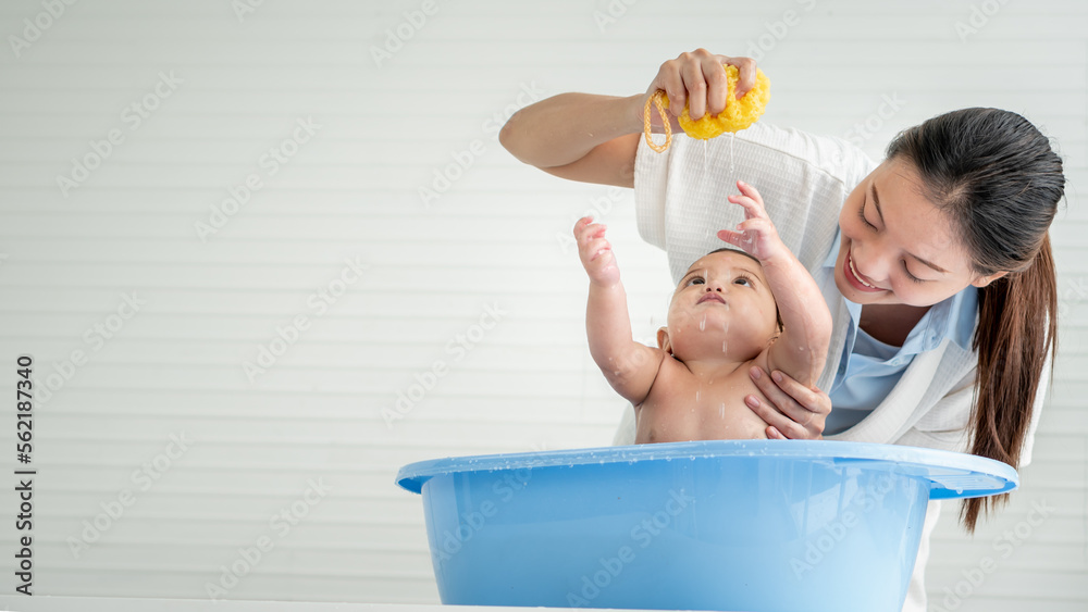 Asian mother Bathing her 7-month-old daughter, which the baby smiling ...