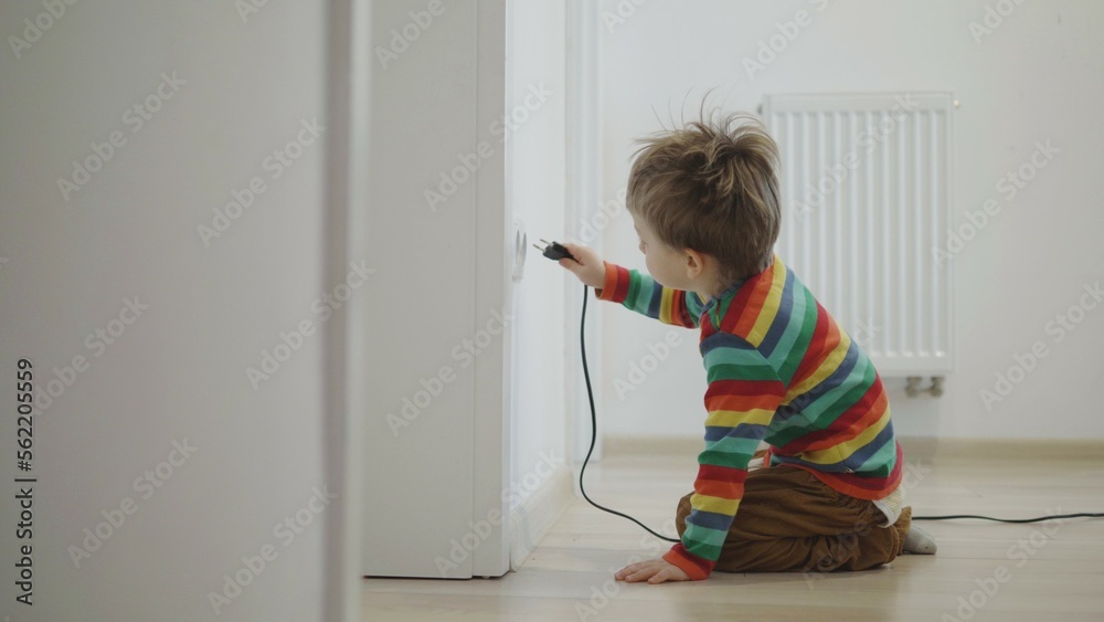 Little kid insert the plug into the socket, risk of electric shock ...