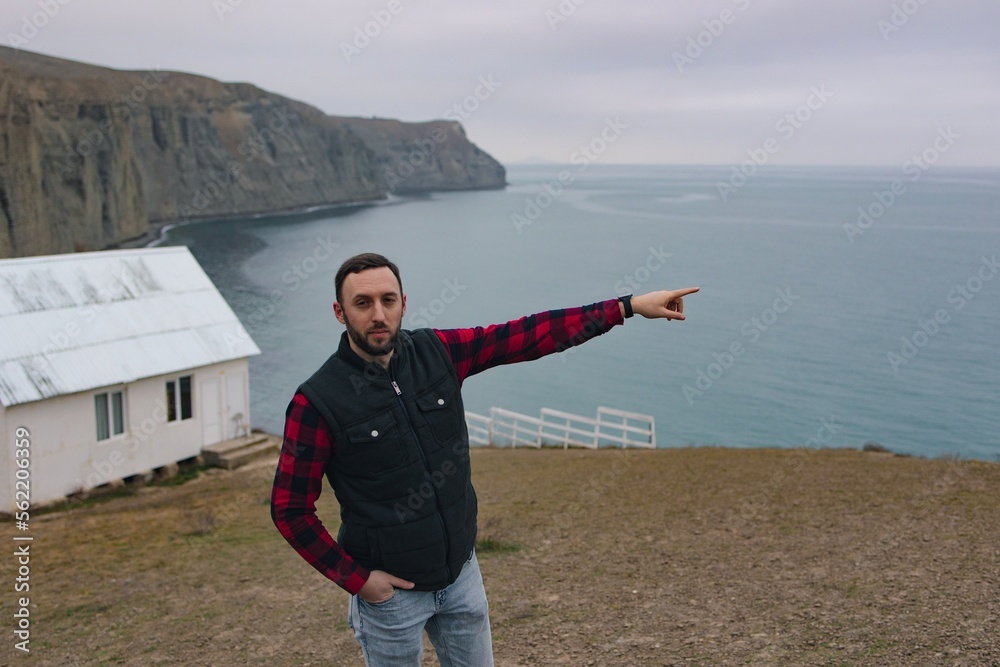 Side view of a tourist pointing with his hand in the right direction ...