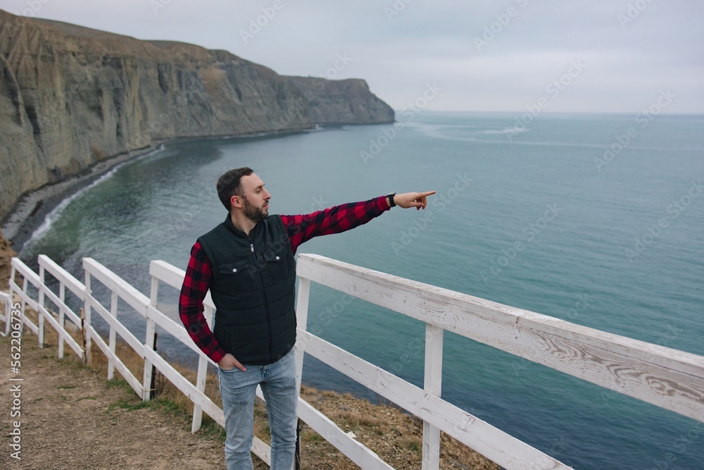 Side view of a tourist pointing with his hand in the right direction ...
