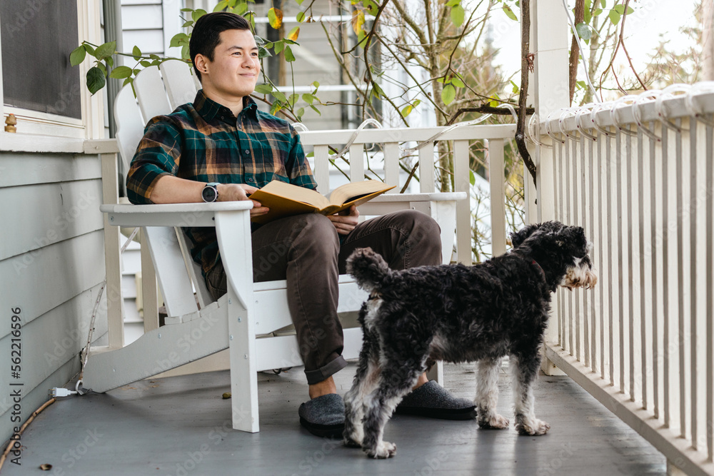 Transgender man with dog on his porch. Stock Photo | Adobe Stock