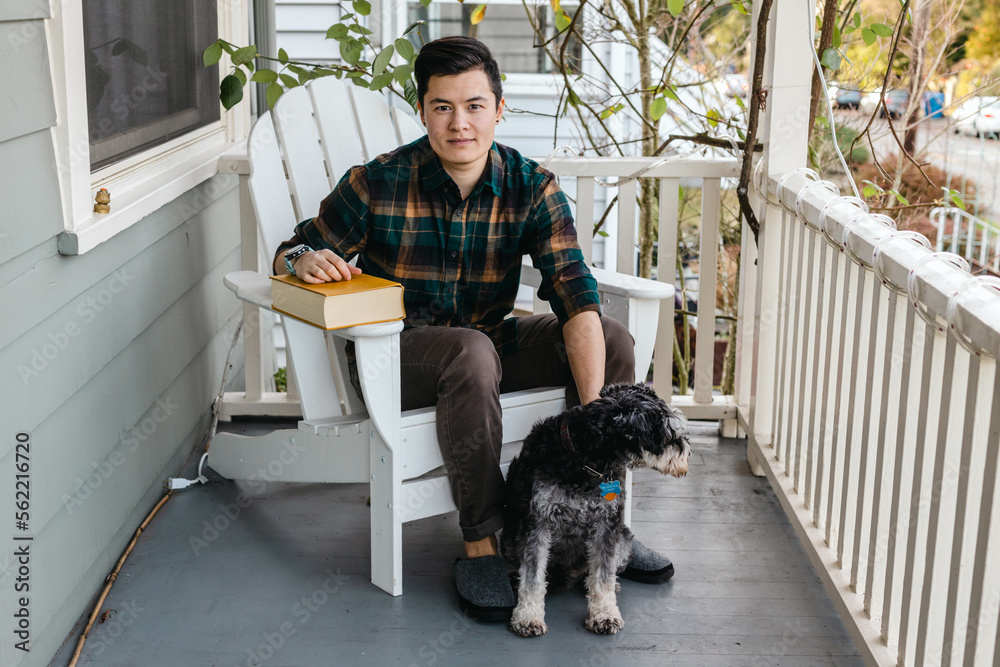 Transgender man with dog on his porch. Stock Photo | Adobe Stock