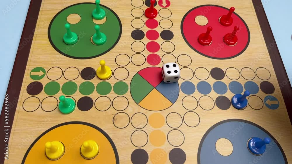 People play Ludo or Pachisi board game on beautiful wooden play board ...