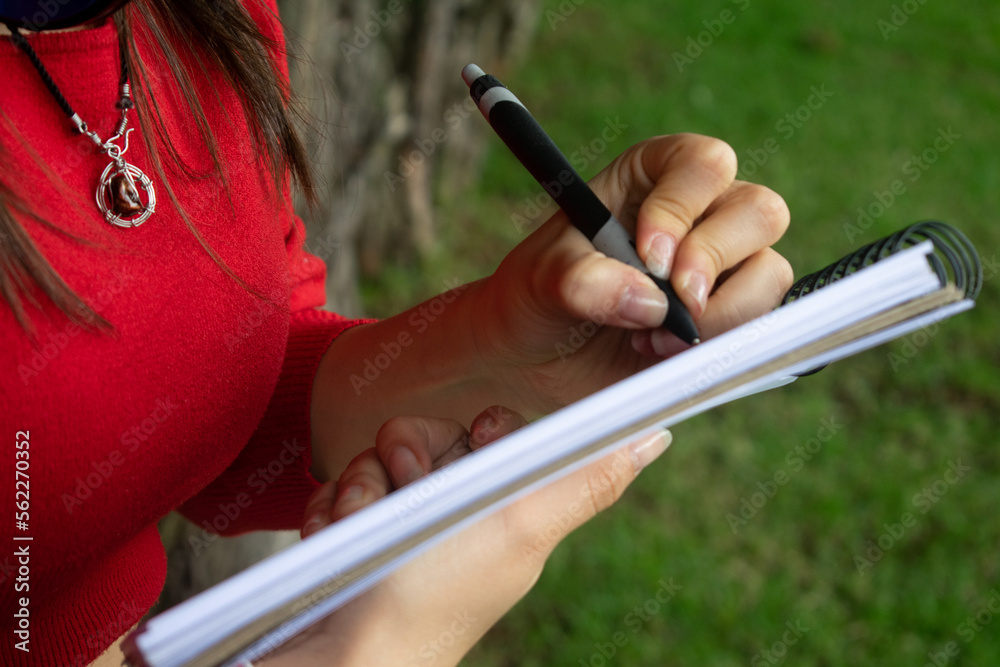 Primer plano de persona escribiendo en su libreta al aire libre Stock ...