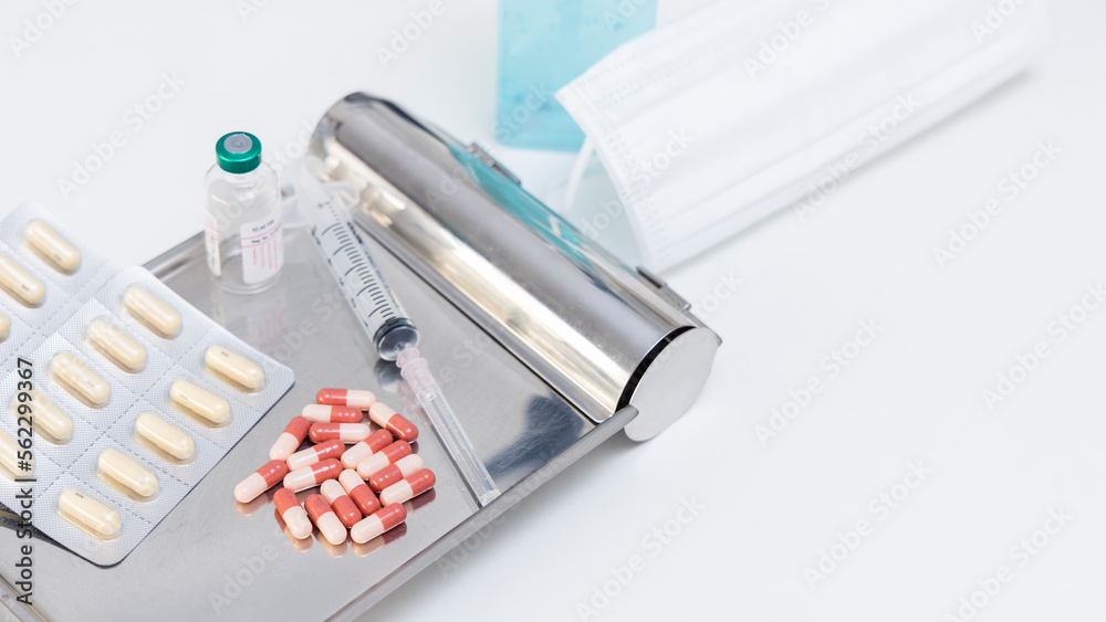 A pharmacist pour and count drug capsules on stainless tray, she ...