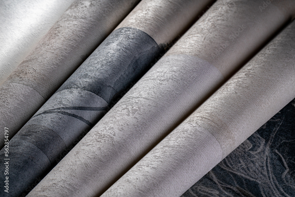 A roll of vinyl wallpaper with a beautiful paper texture in low light ...