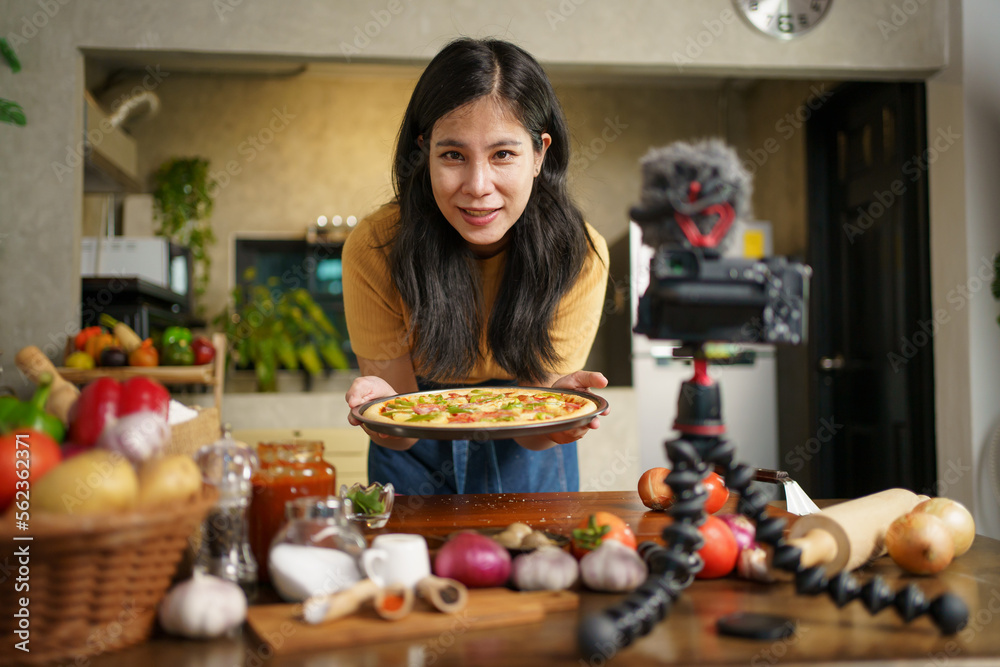 Foto de Beautiful happy Asian female chef baking a homemade pizza and ...