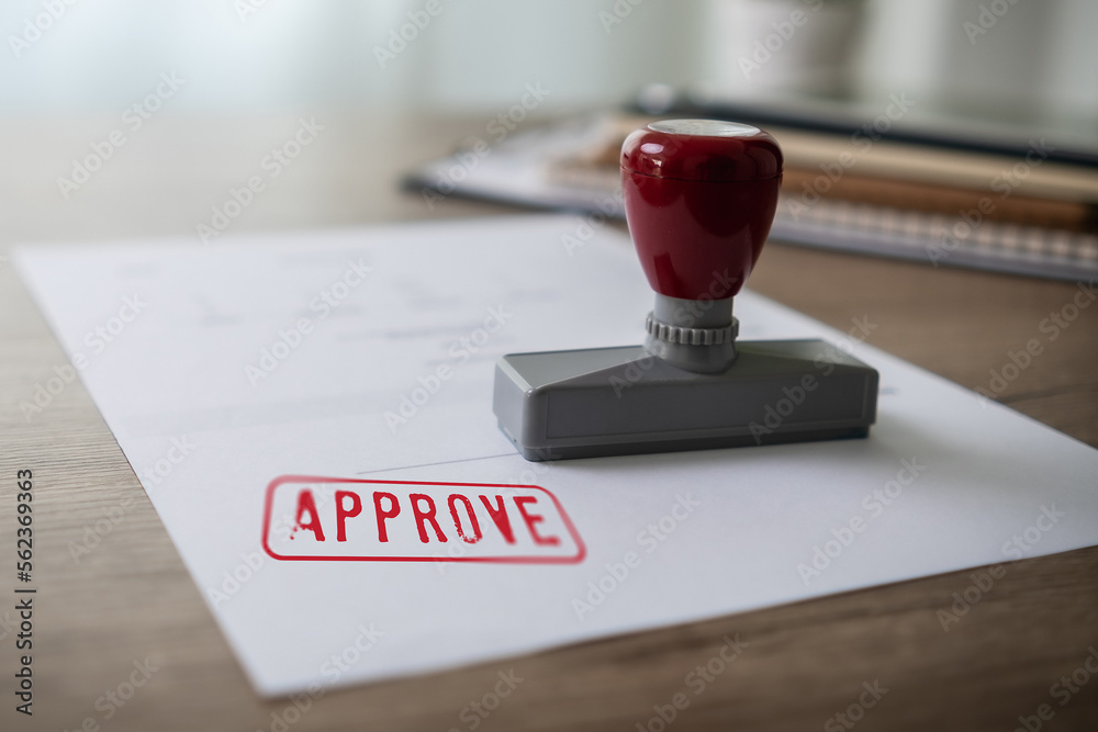 man stamping approval Text is approved by stamping the document on ...