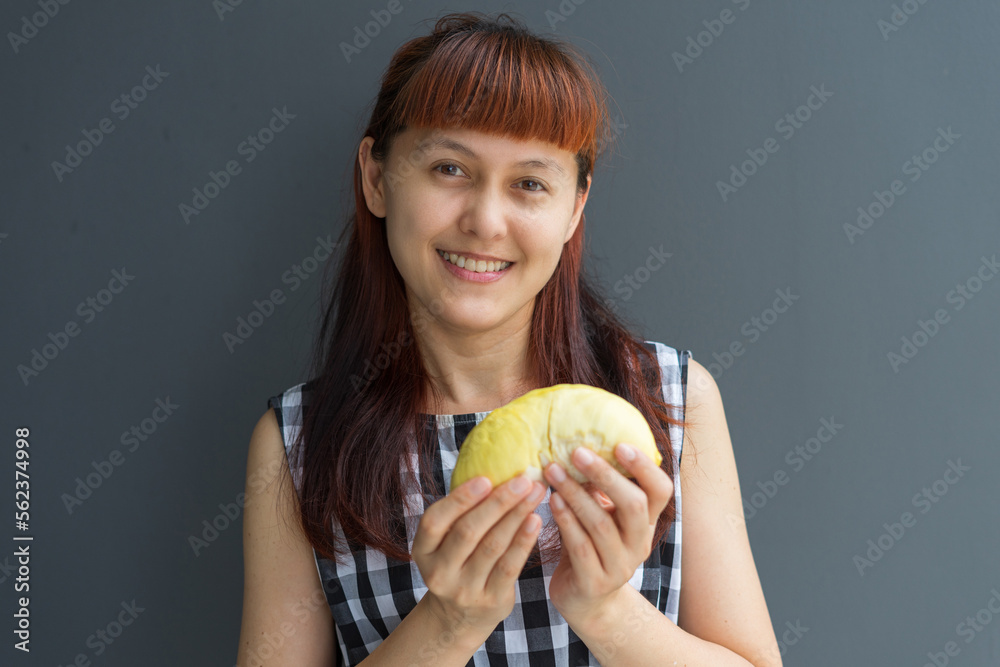Close up A woman handle durian show the yellow durian meat to eat. The ...