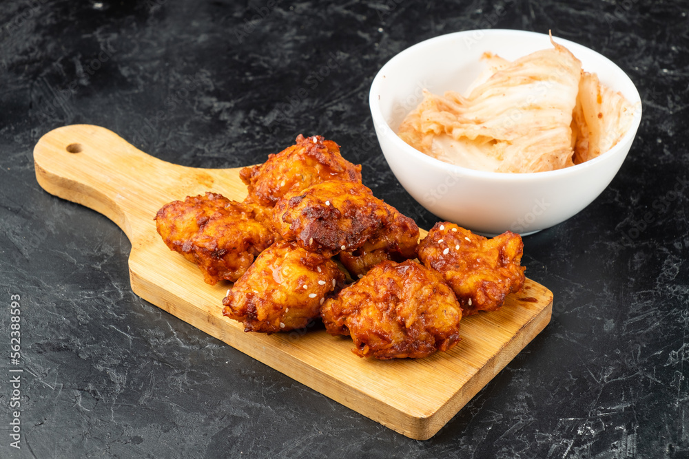Crispy breaded chicken in Asian style spicy sauce and a side of kimchi ...