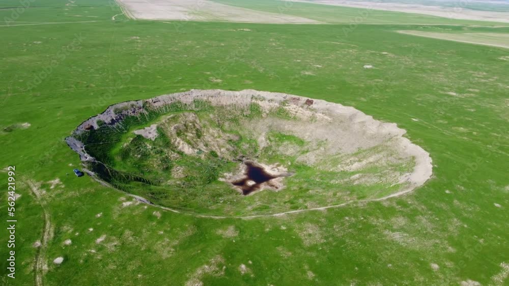 View of the funnel from a nuclear explosion, overgrown with green grass ...