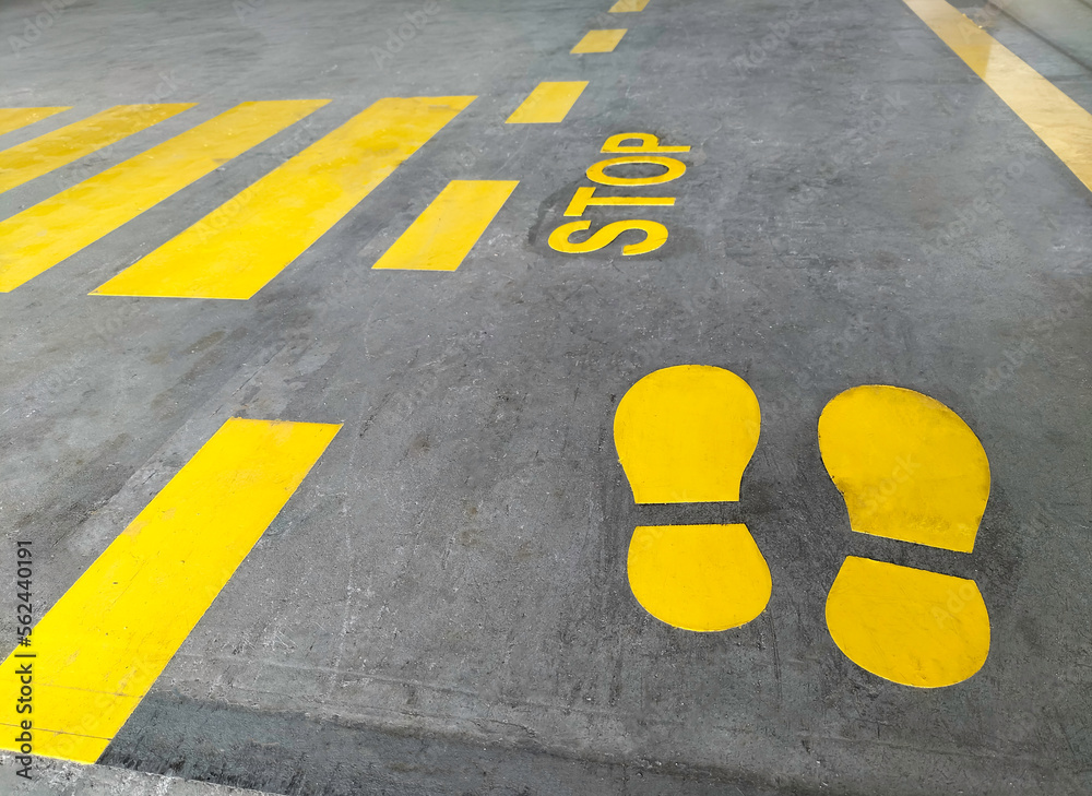 Walkway signs and painted yellow on the factory floor. scratched cement ...
