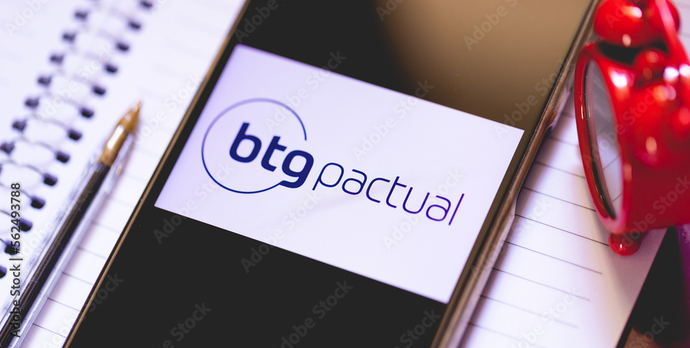 Foto de A logo do banco BTG Pactual na tela de um telefone celular. Um ...