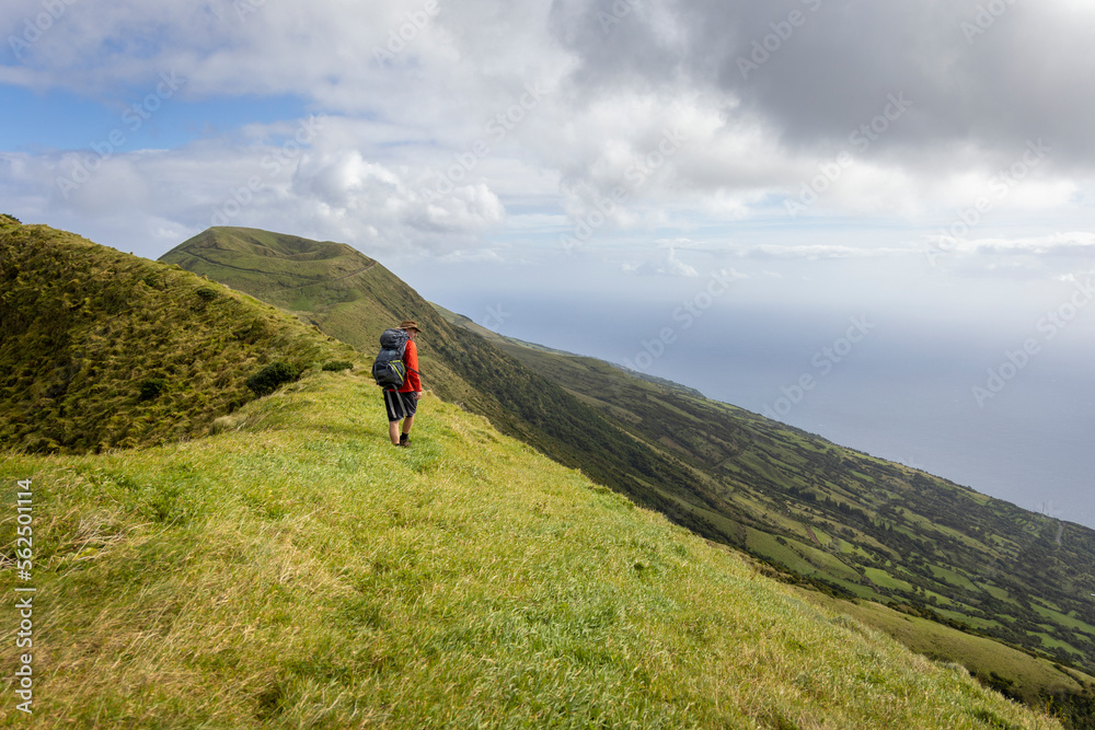 Person hiking along an old volcanic crater rim on São Jorge island in ...