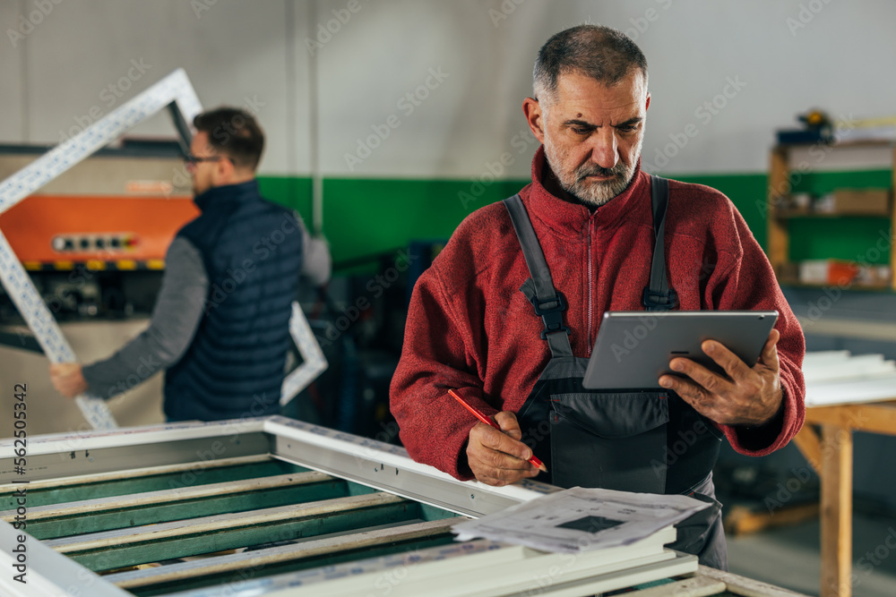 Handyman makes drawings for PVC frames production Stock Photo | Adobe Stock