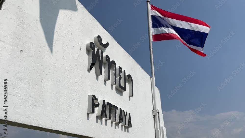 Pattaya city train station sign with Thailand flag flapping blue sky ...
