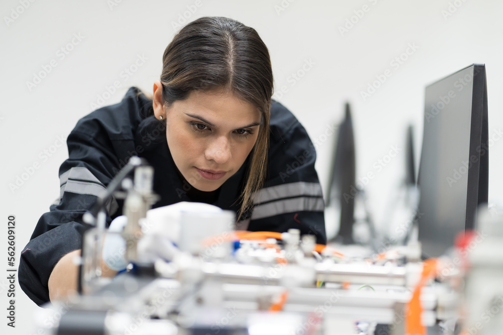Female engineer training AI robot training kit and mechatronics engineering in the manufacturing ...