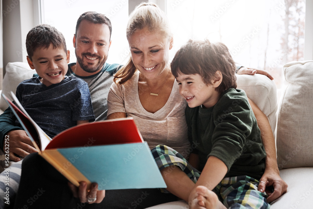 Mom, dad and kids reading book on sofa, storytelling time in living ...