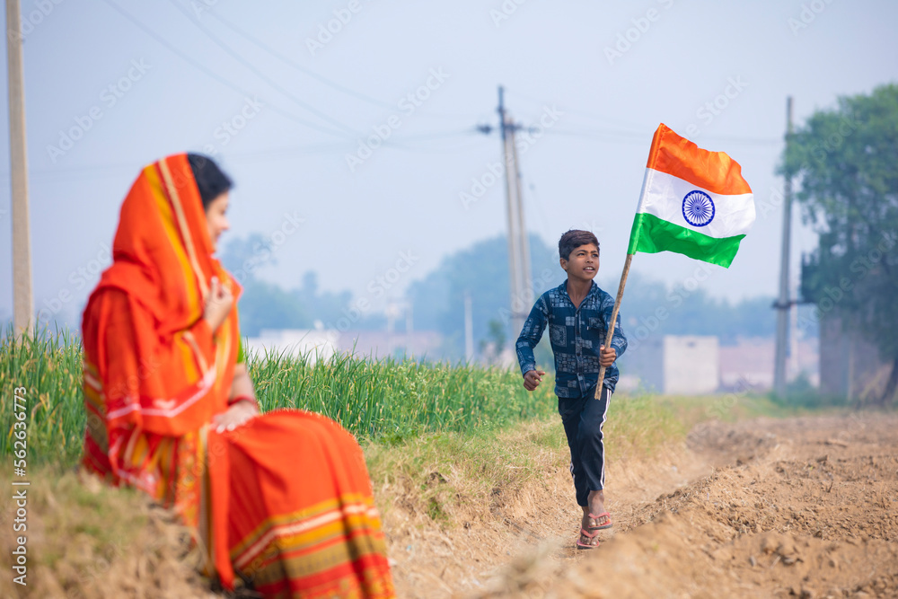 Indian little boy running and waving national flag and his mother ...