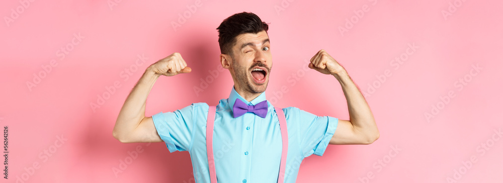 Strong and funny guy with french moustache, flexing biceps and winking ...