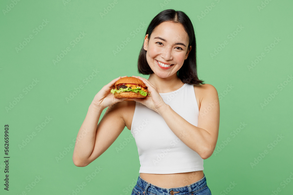 Young smiling happy fun woman wearing white clothes holding eating ...