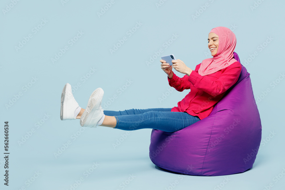 Full body fun young arabian muslim woman wear pink abaya hijab sit in ...
