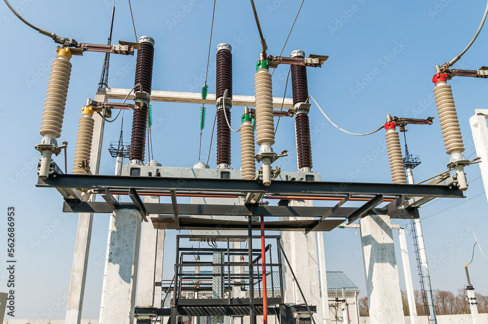 Part of high-voltage substation on blue sky background with switches ...