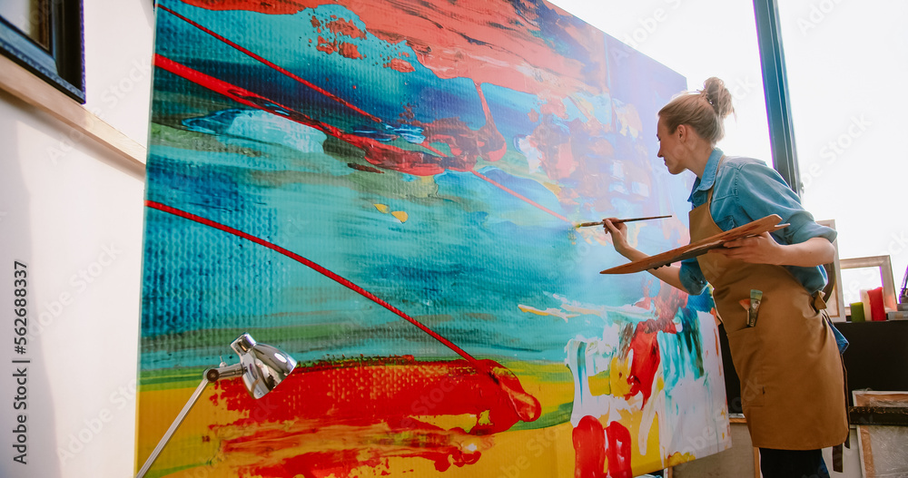 Foto de Side view of Caucasian young pretty talented female painter ...