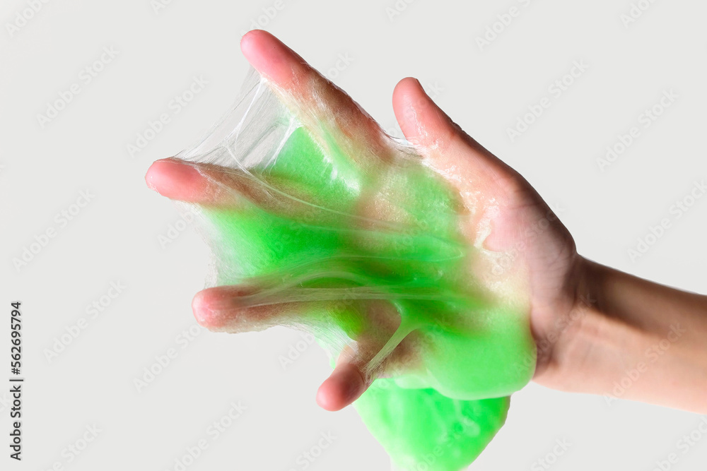 Hand Playing with textured slime on white background. Teen hand holding ...