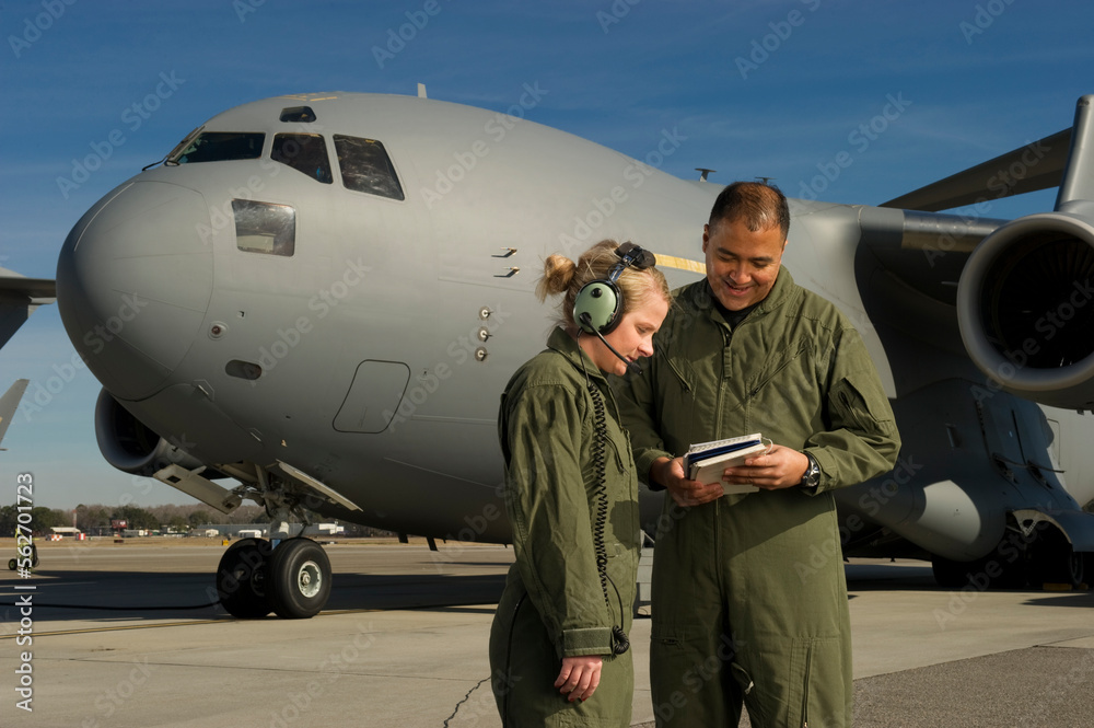 U.S. Air Force loadmasters conduct a preflight checklist during engine ...