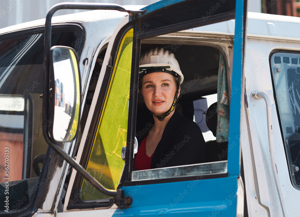 Engineer woman wears safety helmet sitting in a truck. Portrait of ...