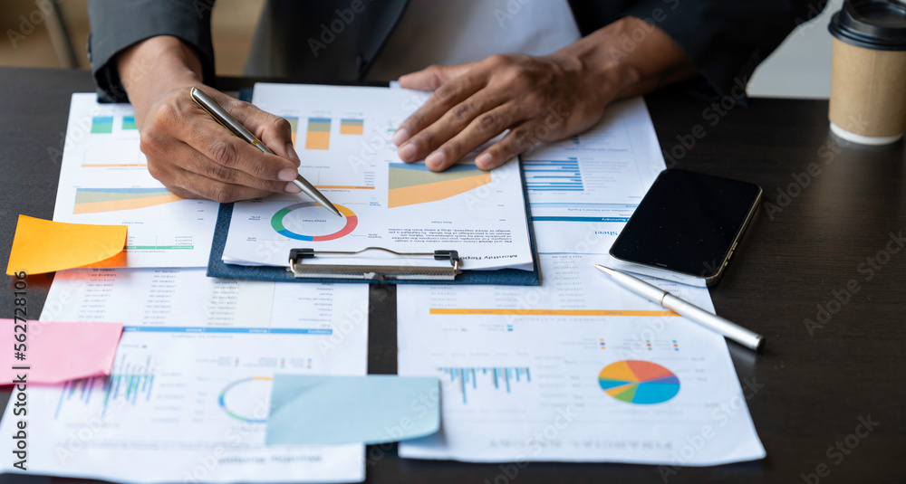 Foto de Young Asian businessman discussing graphs with hands and ...
