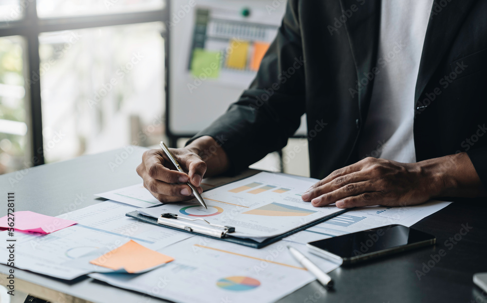 Young Asian businessman discussing graphs with hands and analyzing data ...