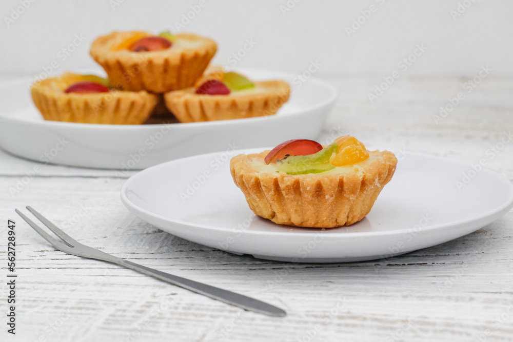 Small fruit pia cake on a textured white background. Kue Pia Buah ...