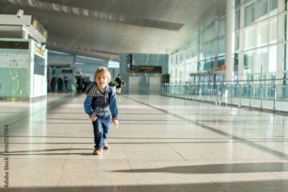 Cute baby boy waiting boarding to flight in airport transit hall near ...