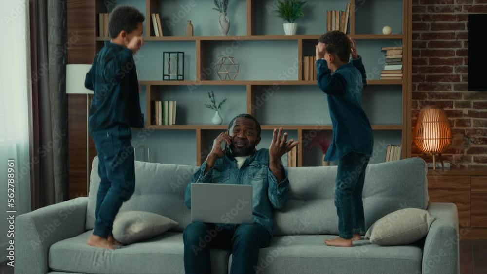 Angry stressed African American ethnic father man work with laptop ...