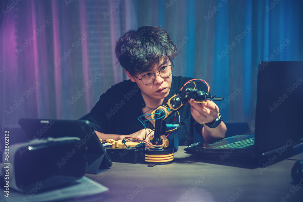 Concentrate Young Adult Asian Female System Engineer Repairing Robotic Arm Model For Learning