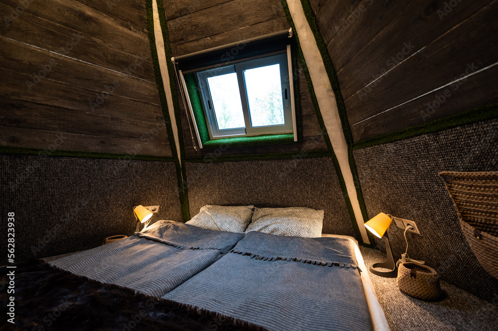 Double bed in bedroom of pyramid shape wooden cabin. Pyramid shape ...