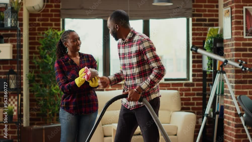Young couple doing spring cleaning together in apartment space, focused ...