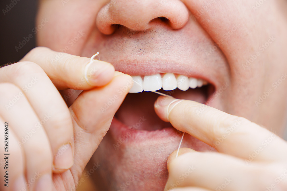 a man's mouth close-up. a man brush your teeth with dental floss ...