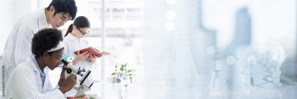 Asian teacher and diverse student doing tests of plants in classroom ...