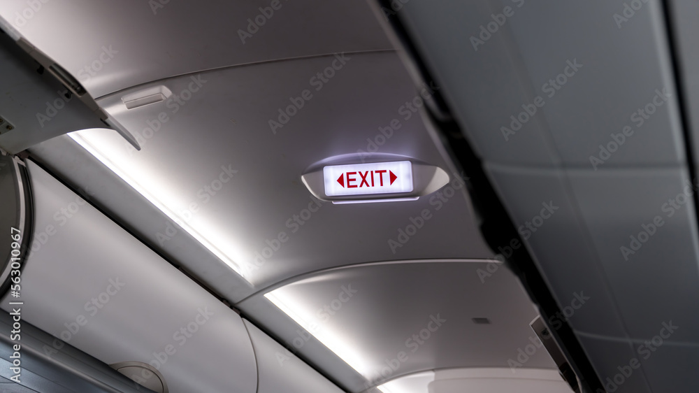 Foto de Exit sign in passenger airplane. Emergency exit sign on ...