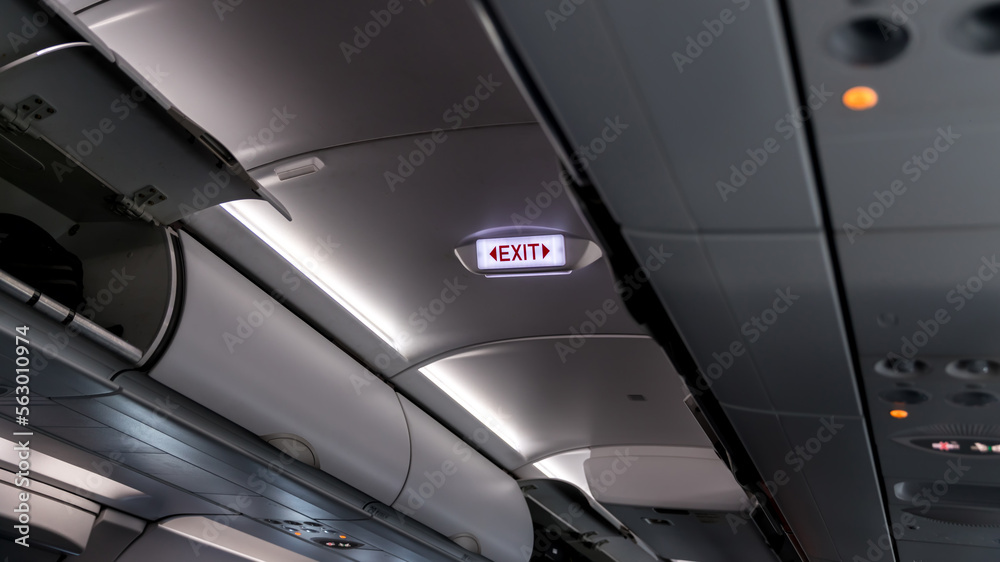 Foto de Exit sign in passenger airplane. Emergency exit sign on ...